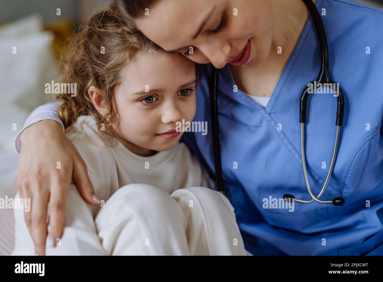 Young doctor hugging little girl in hospital room Stock Photo - Alamy