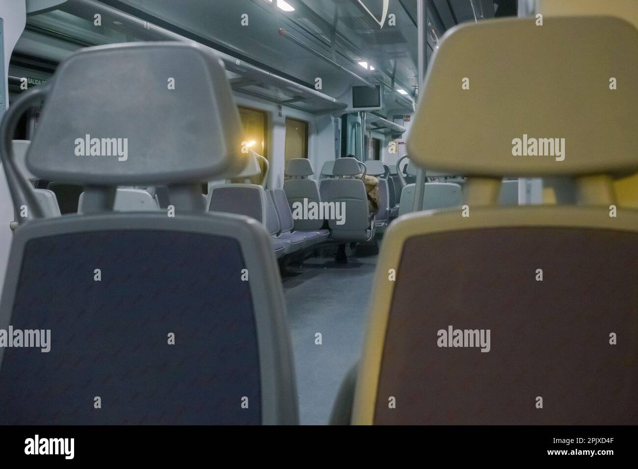 A dark view of the back of seats in a railway carriage with a bright ...