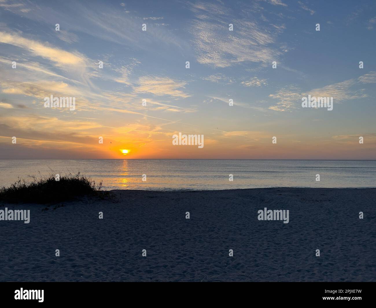 A view of a Sunset on the beach at Siesta Key, Florida with a beautiful ...