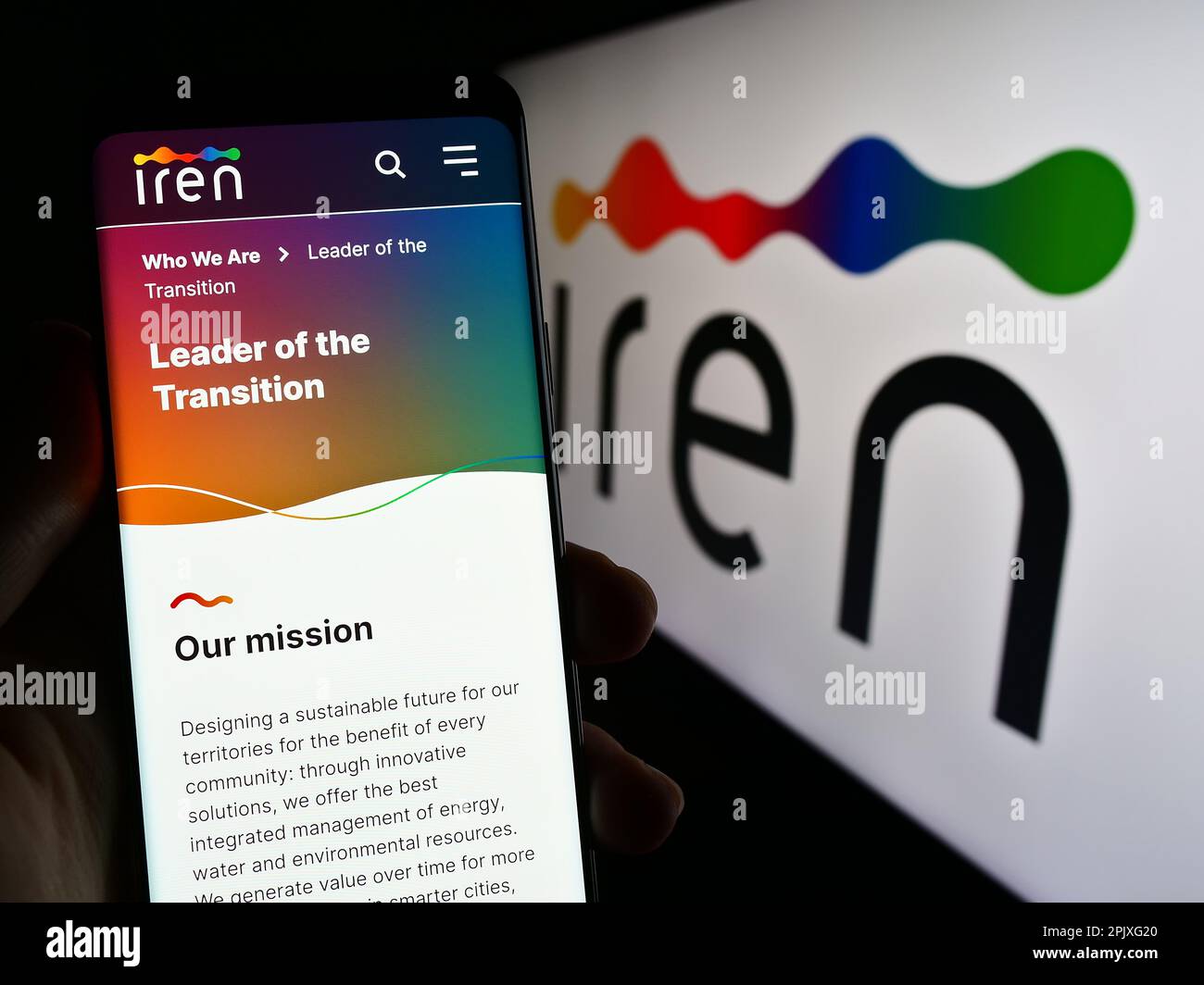 Person holding smartphone with web page of Italian utility company Iren ...