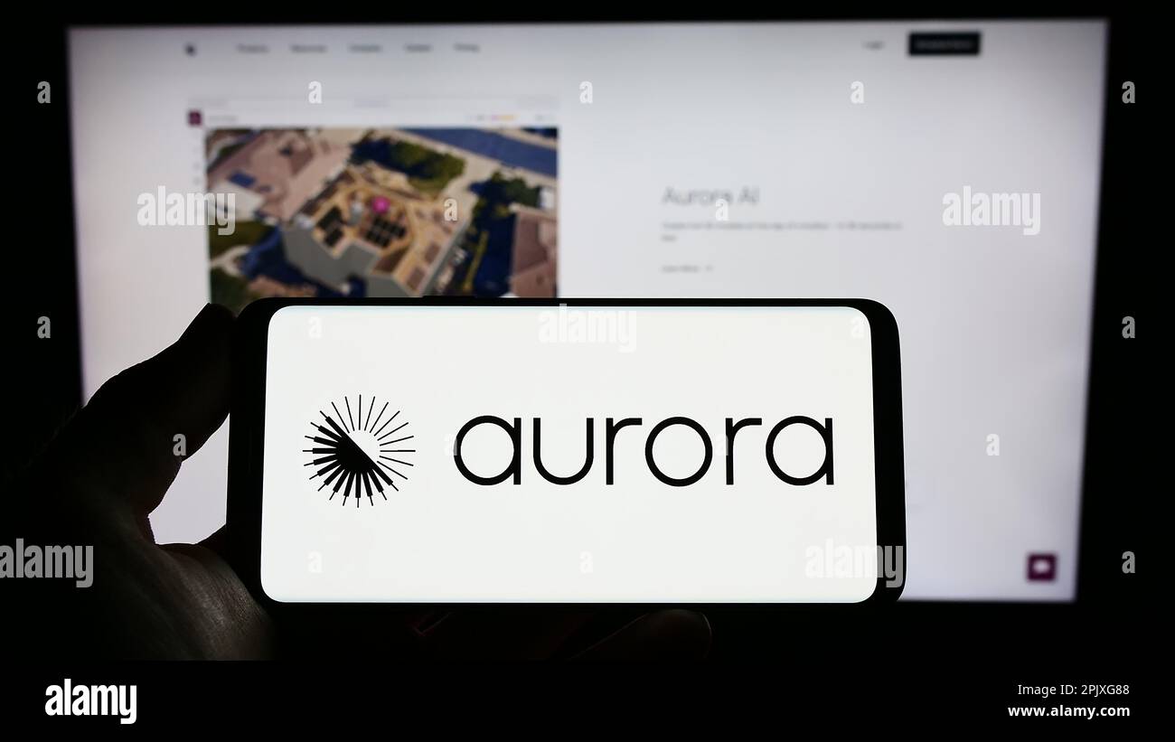 Person holding smartphone with logo of US energy software company Aurora Solar Inc. on screen in ...