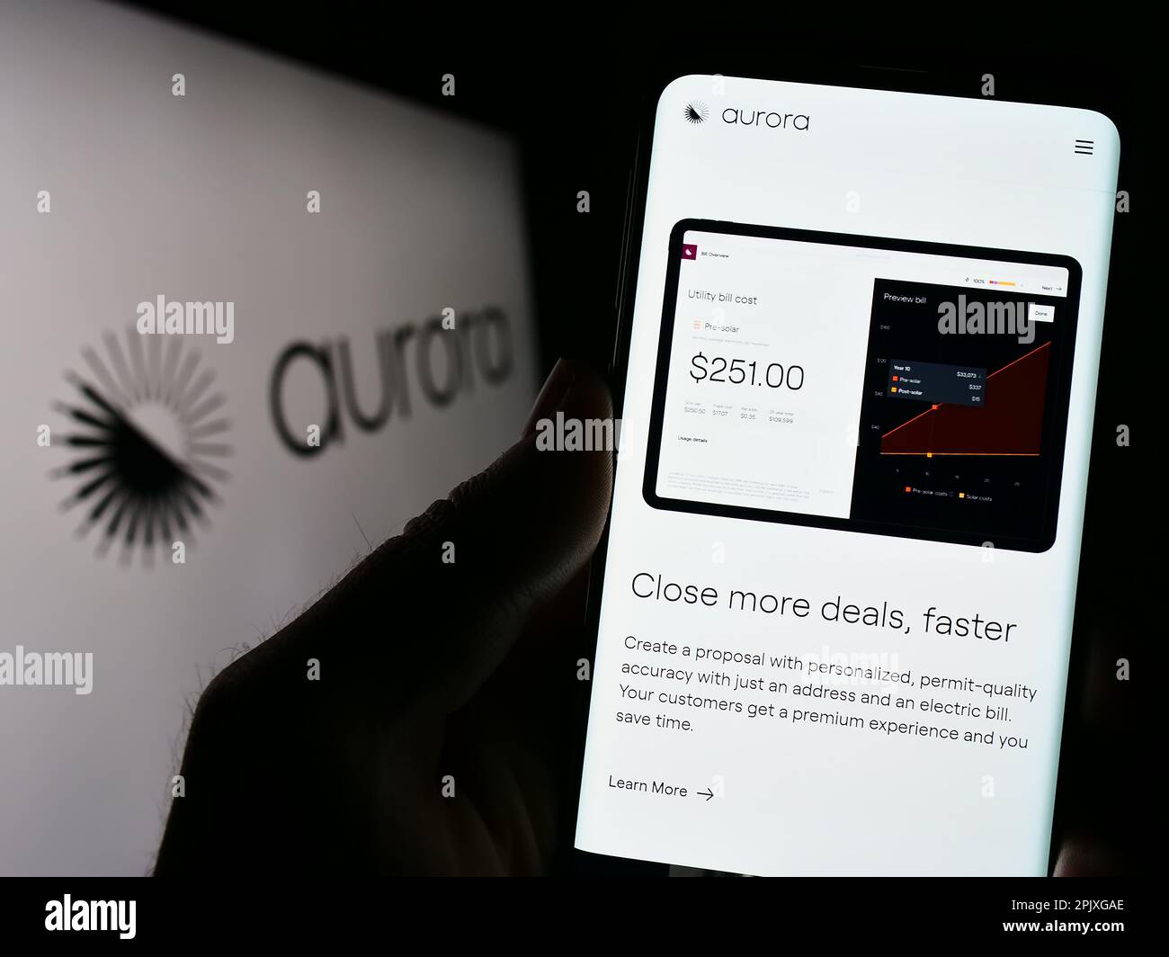 Person holding cellphone with webpage of US energy software company ...