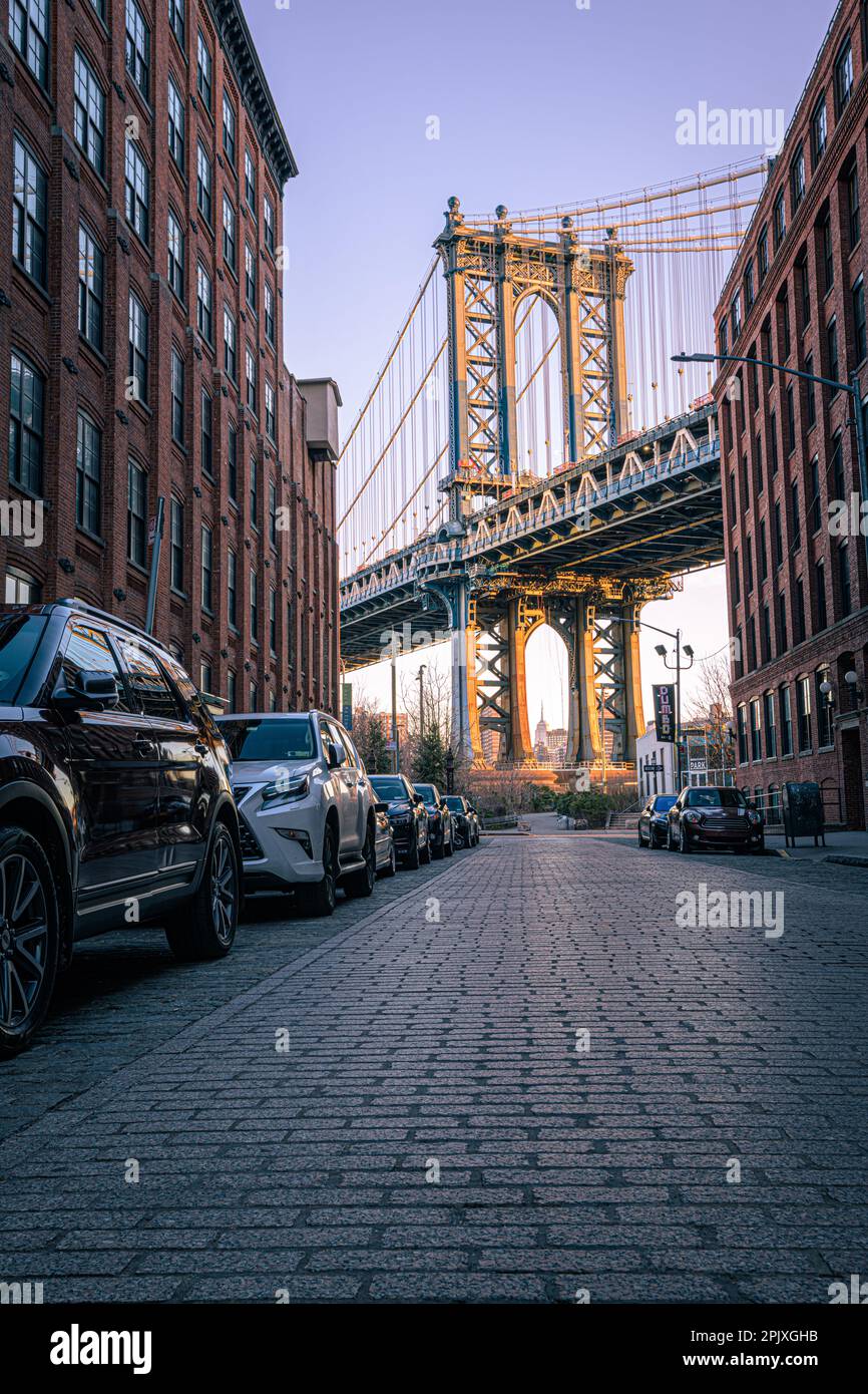 Manhattan Bridge from the Street, between two buildings at sunrise ...