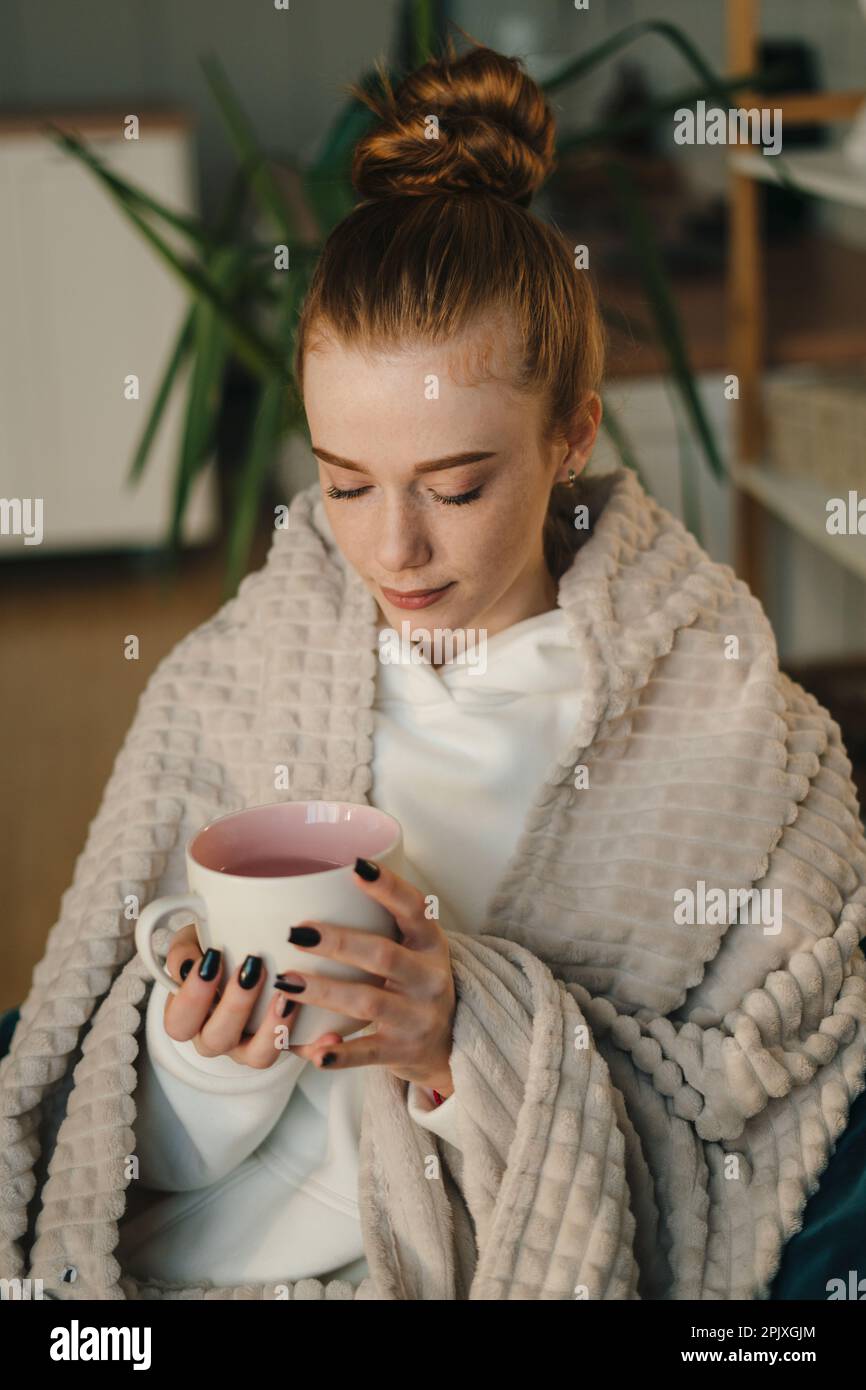 Portrait of a young beautiful ginger woman with cup of coffee sitting ...