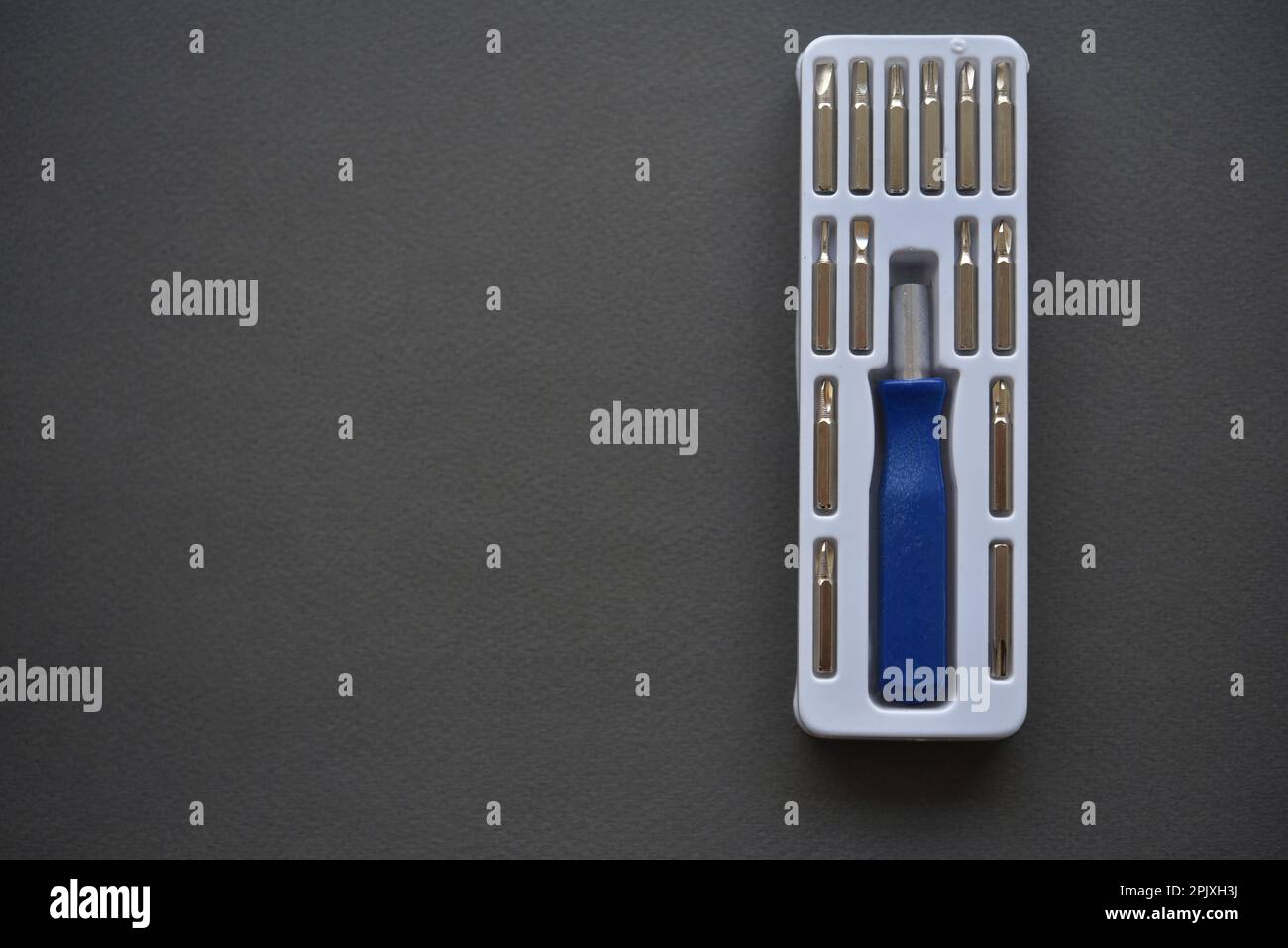A set of screwdrivers with nozzles on a gray background. Replaceable ...