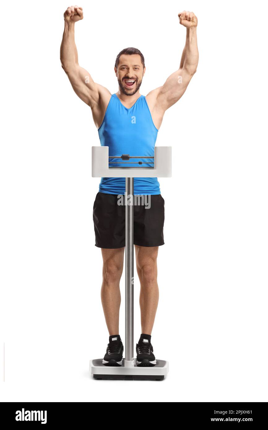 Fit young man weighing on a medical scale and gesturing happiness ...