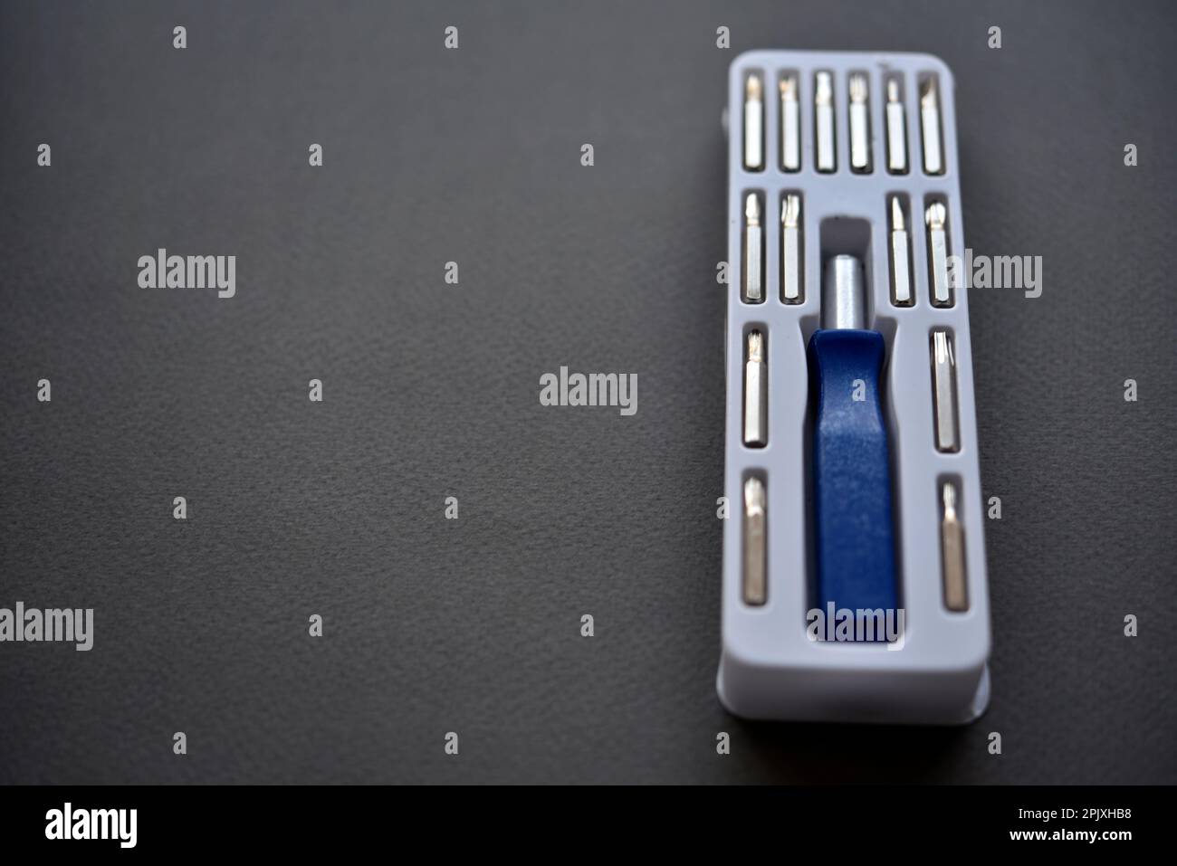 A set of screwdrivers with nozzles on a gray background. Replaceable ...