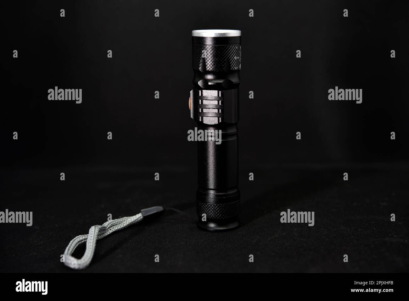 Metal black flashlight on a black background. Pocket flashlight Stock ...