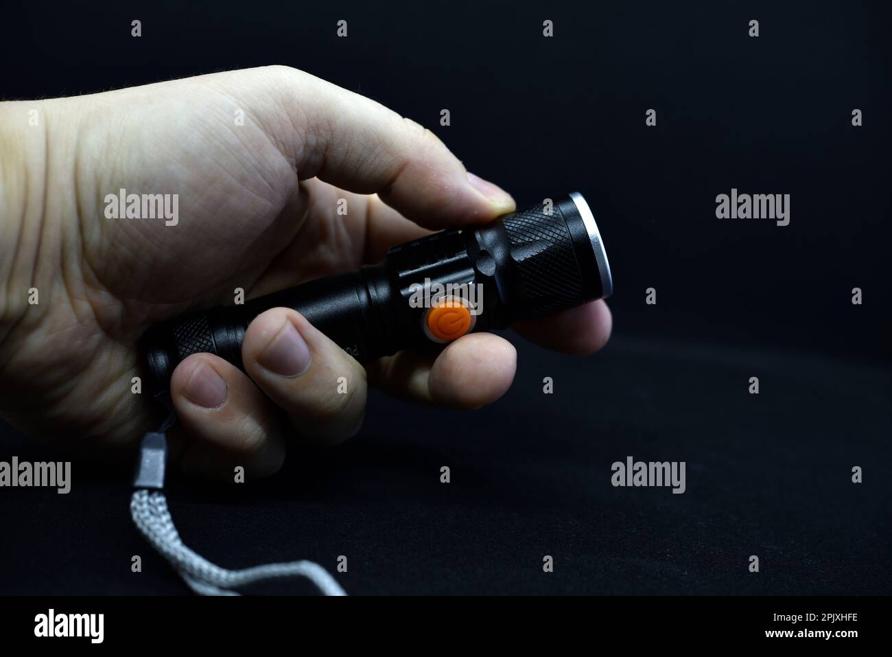 Metal black flashlight in hand. Pocket flashlight Stock Photo - Alamy