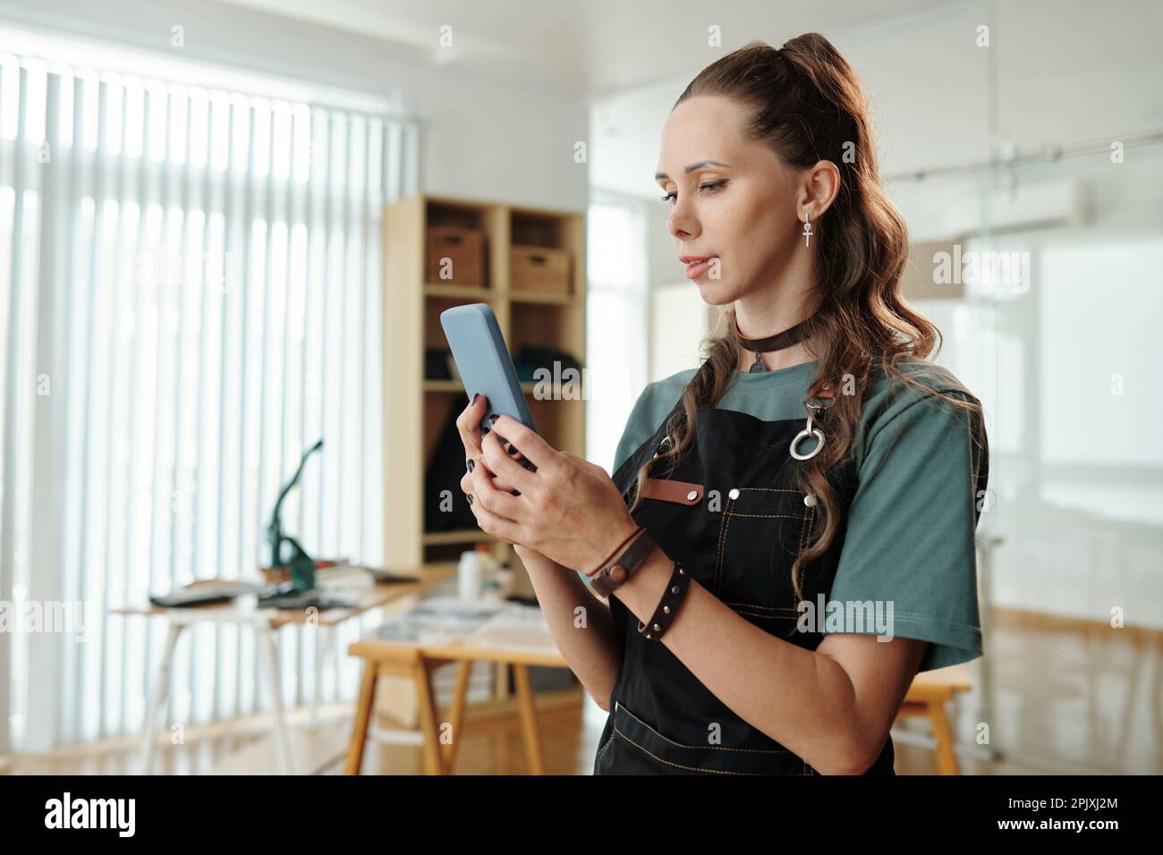 Custom leather goods shop owner reading feedback from customers Stock ...
