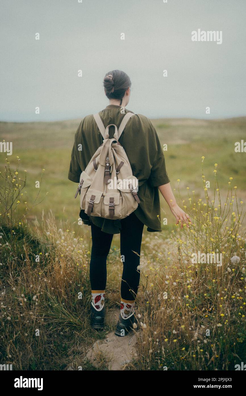 A female hiker trekking in the wilderness with a fully loaded backpack ...