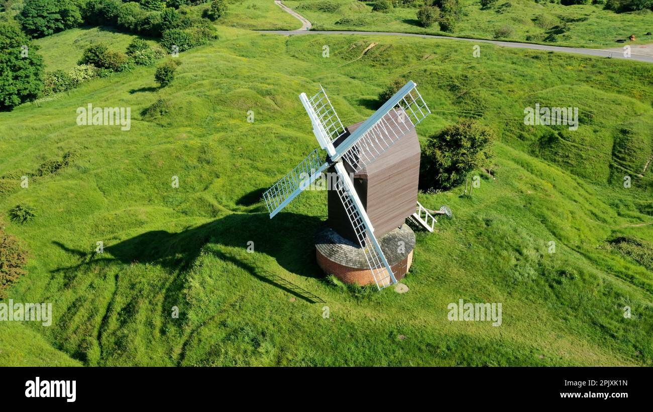 An aerial view of a traditional windmill in a grassy meadow, situated ...