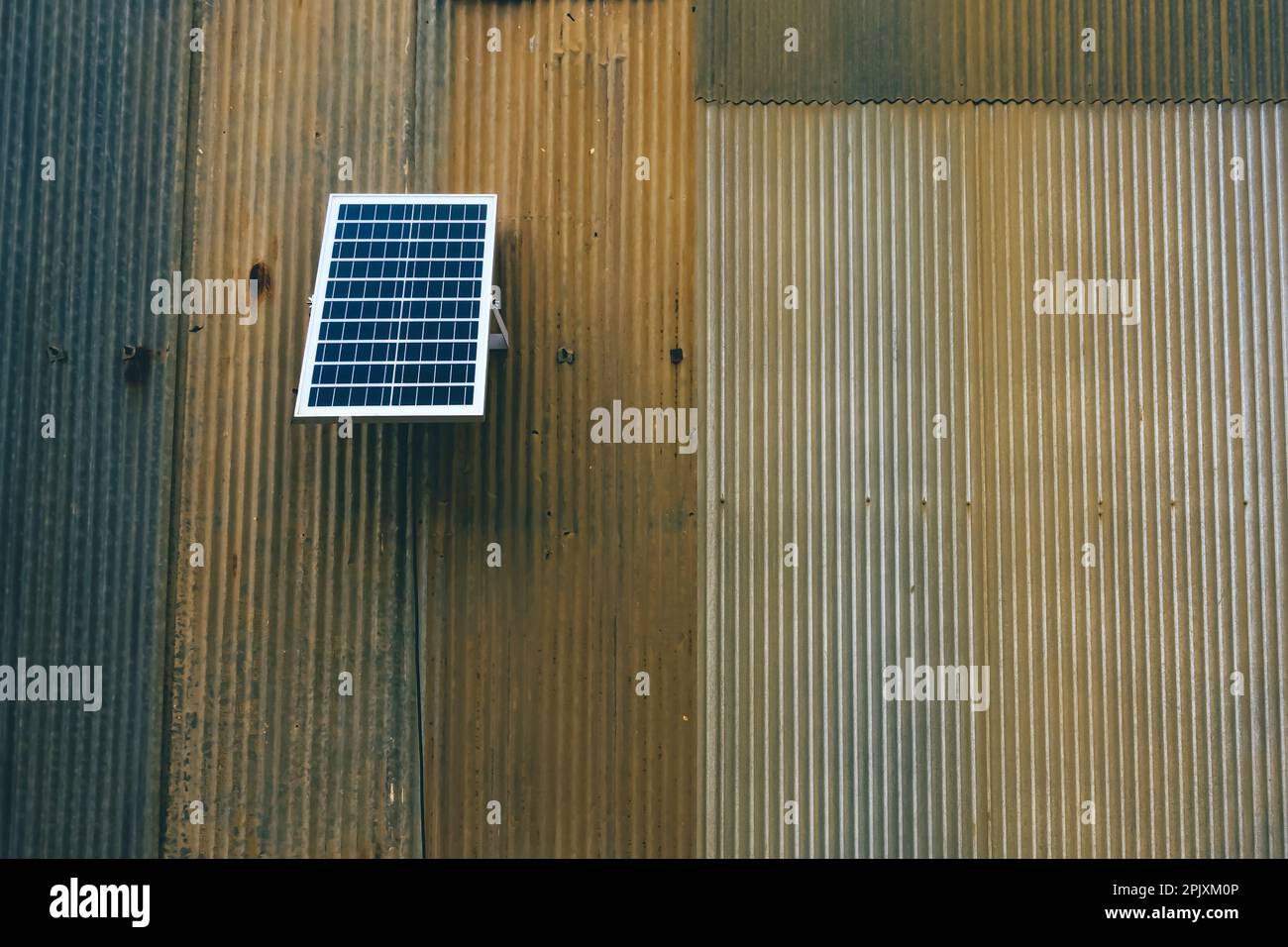 Solar panel attached on old zinc wall. Electric solar panel on the ...