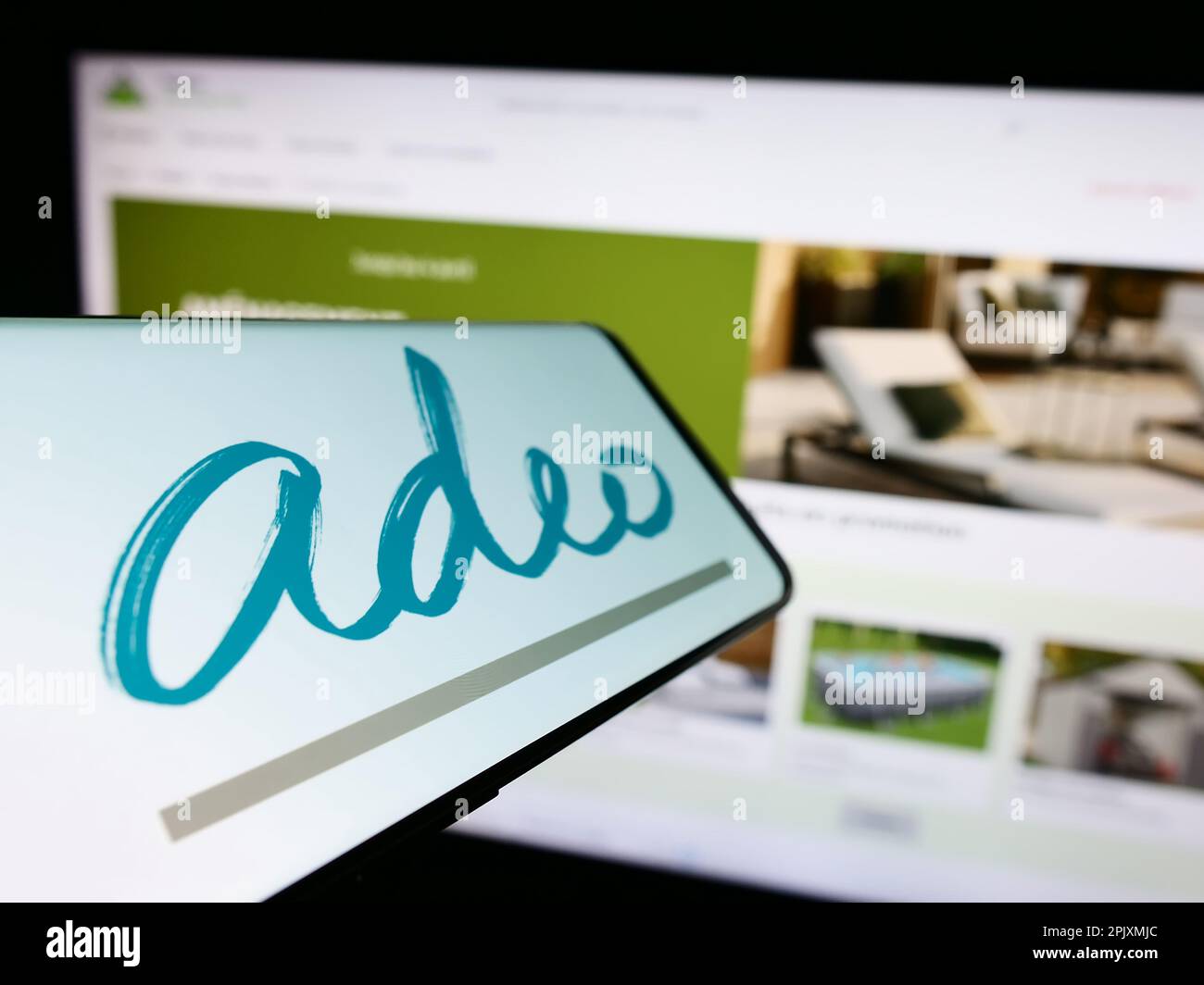 Smartphone with logo of French retail company Adeo SA on screen in front of business website ...