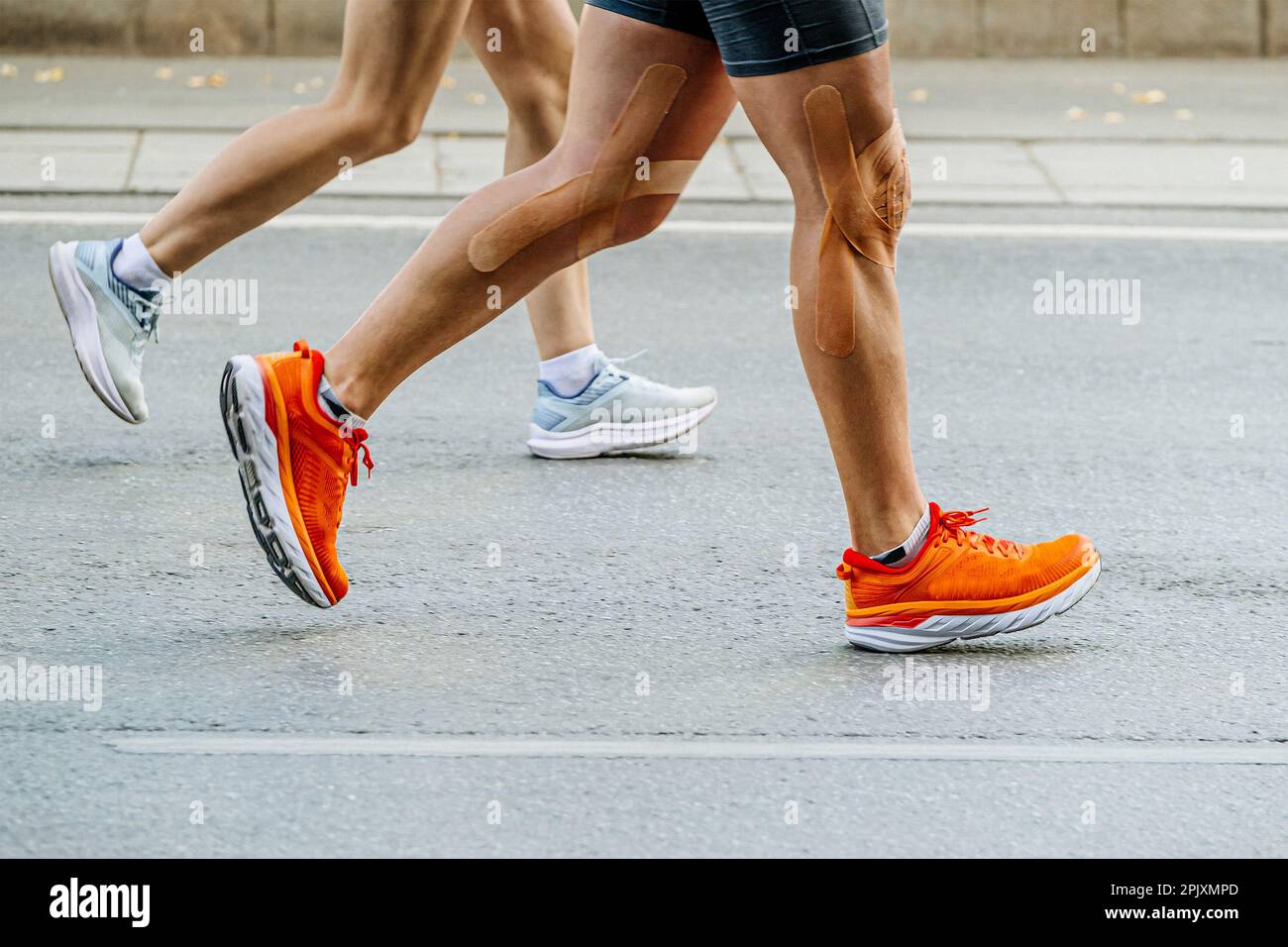 legs man and woman run together city marathon race, male kinesiotaping ...