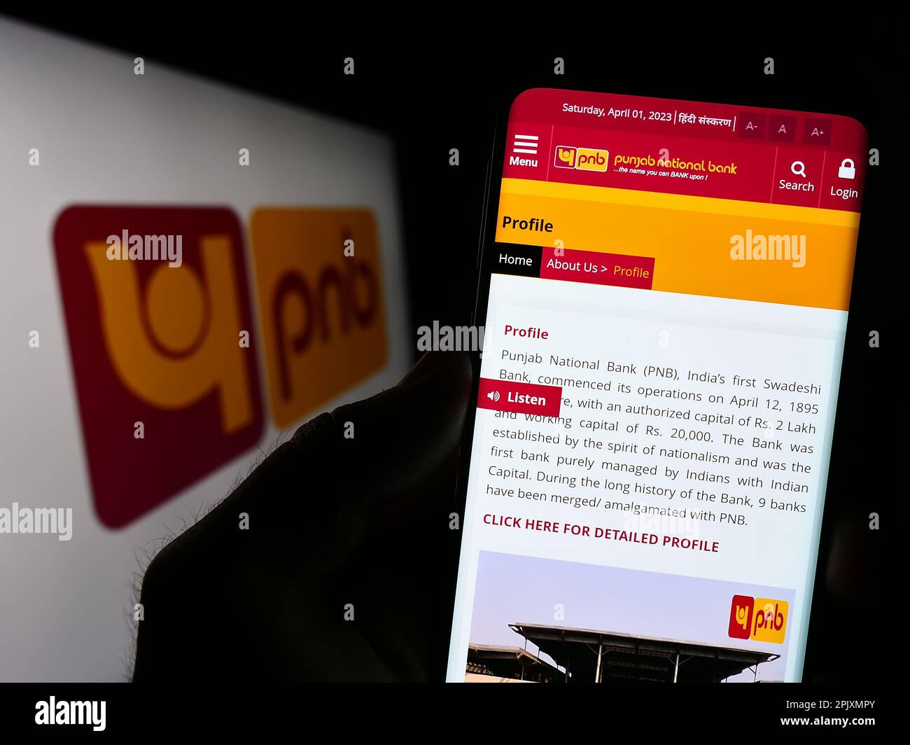 Person holding cellphone with webpage of Indian company Punjab National ...