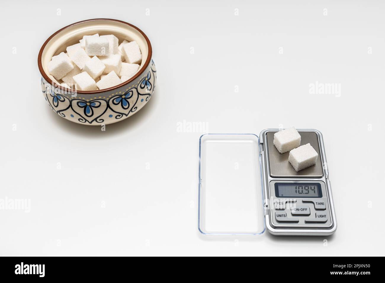 a sugar cube lies on a small scale. sugar control. sugar cubes in a ...