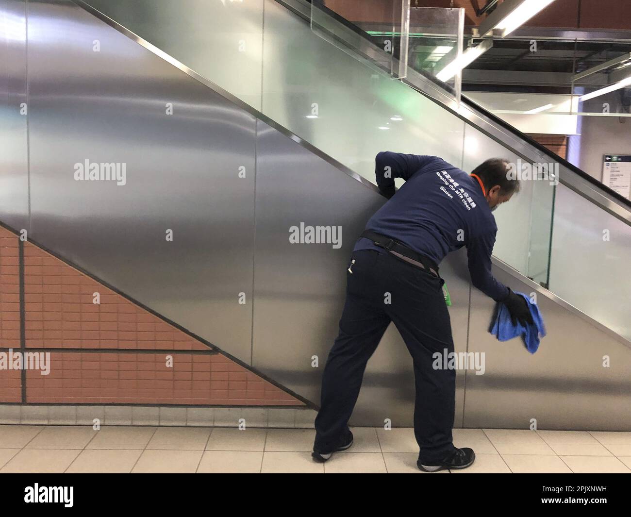 Artist Luke Ching Chin-wai keeping the escalator handrail germ-free at ...