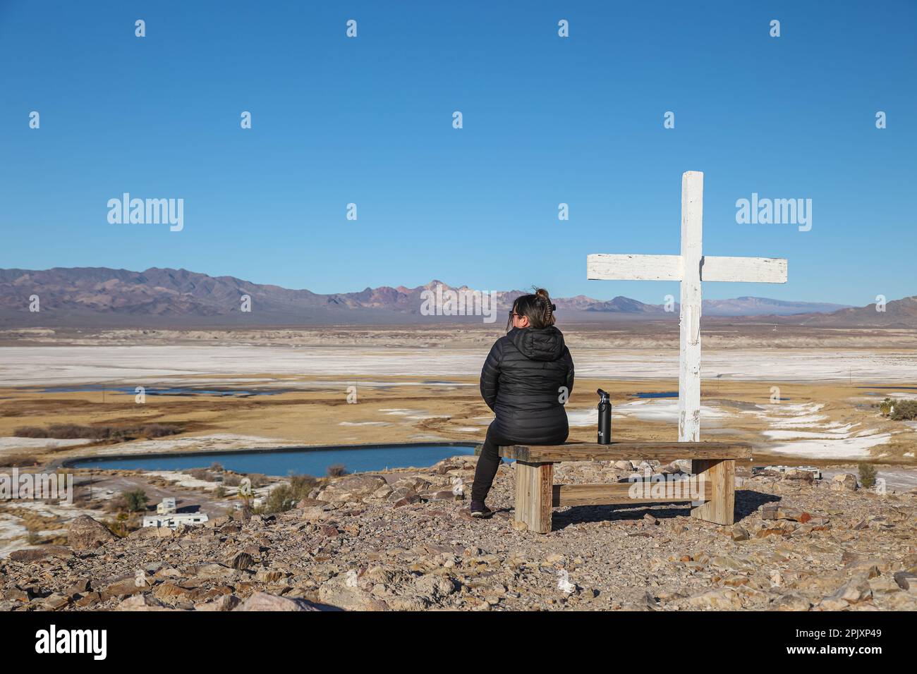 A woman sits beside the Old Rugged Cross along the hiking trail in the ...