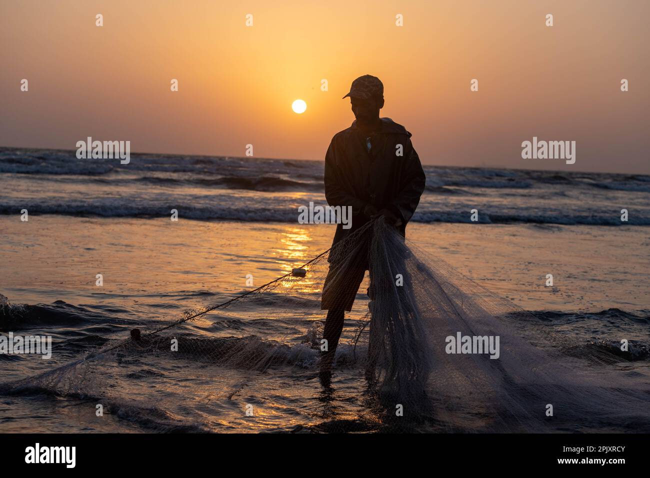 karachi pakistan 2021, a fisherman pulling fishing net to catch fish ...