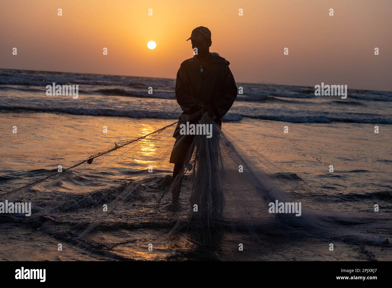 karachi pakistan 2021, a fisherman pulling fishing net to catch fish ...
