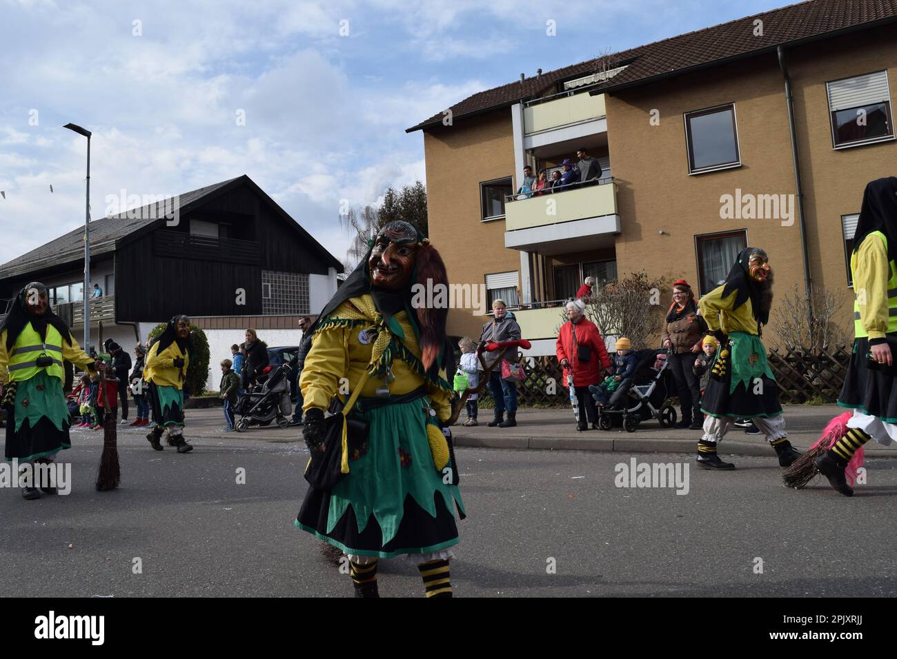 A group of people wearing colorful costumes are marching on a ...