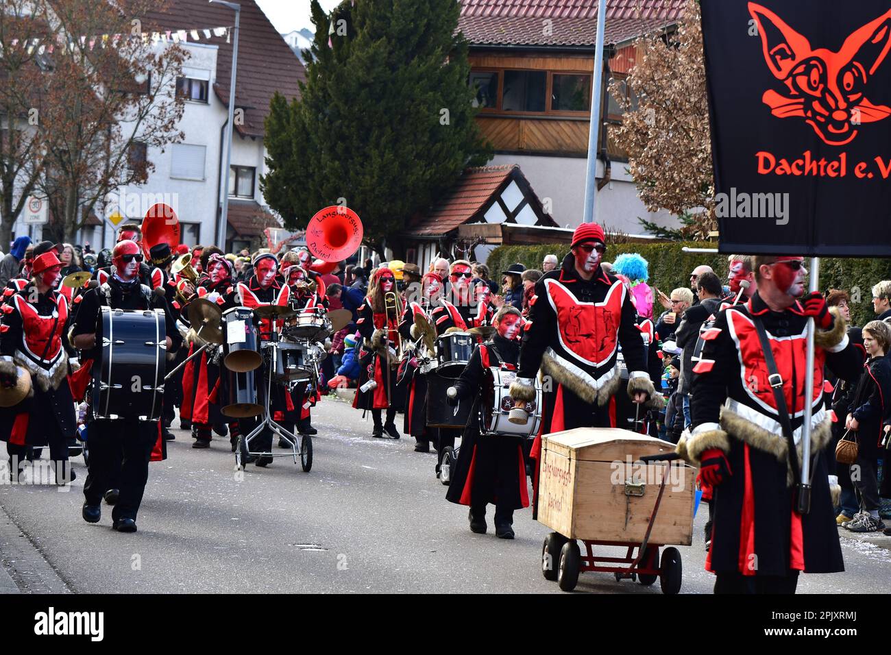 A group of people wearing colorful costumes are marching on a ...