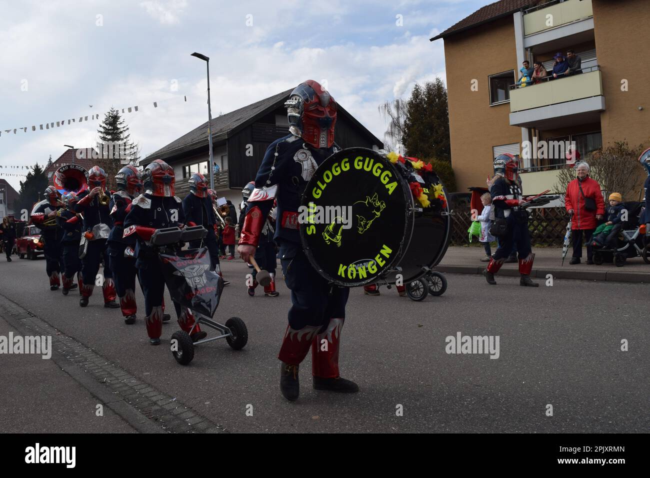 A marching band wearing colorful costumes is seen parading down a ...