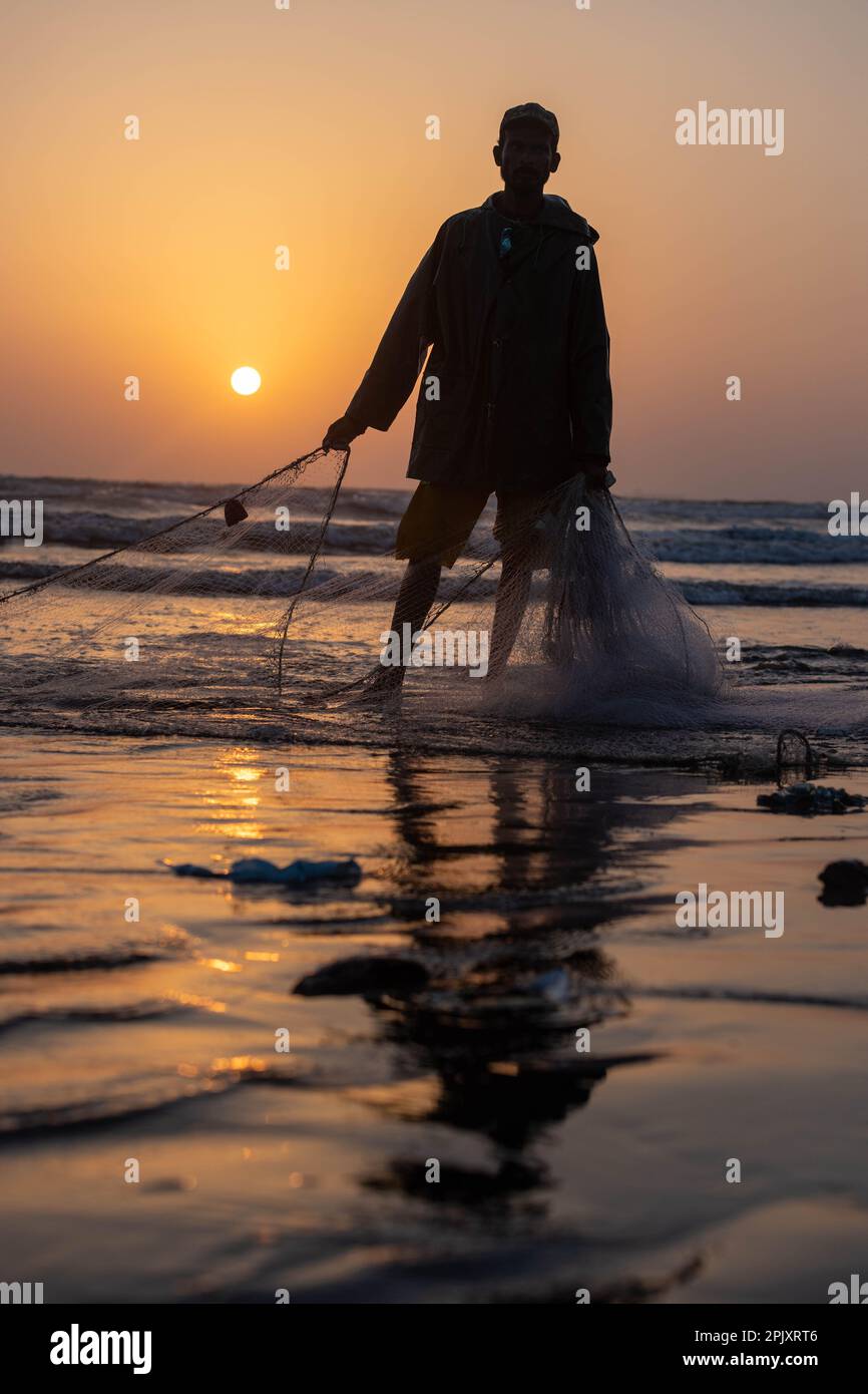 karachi pakistan 2021, a fisherman pulling fishing net to catch fish ...