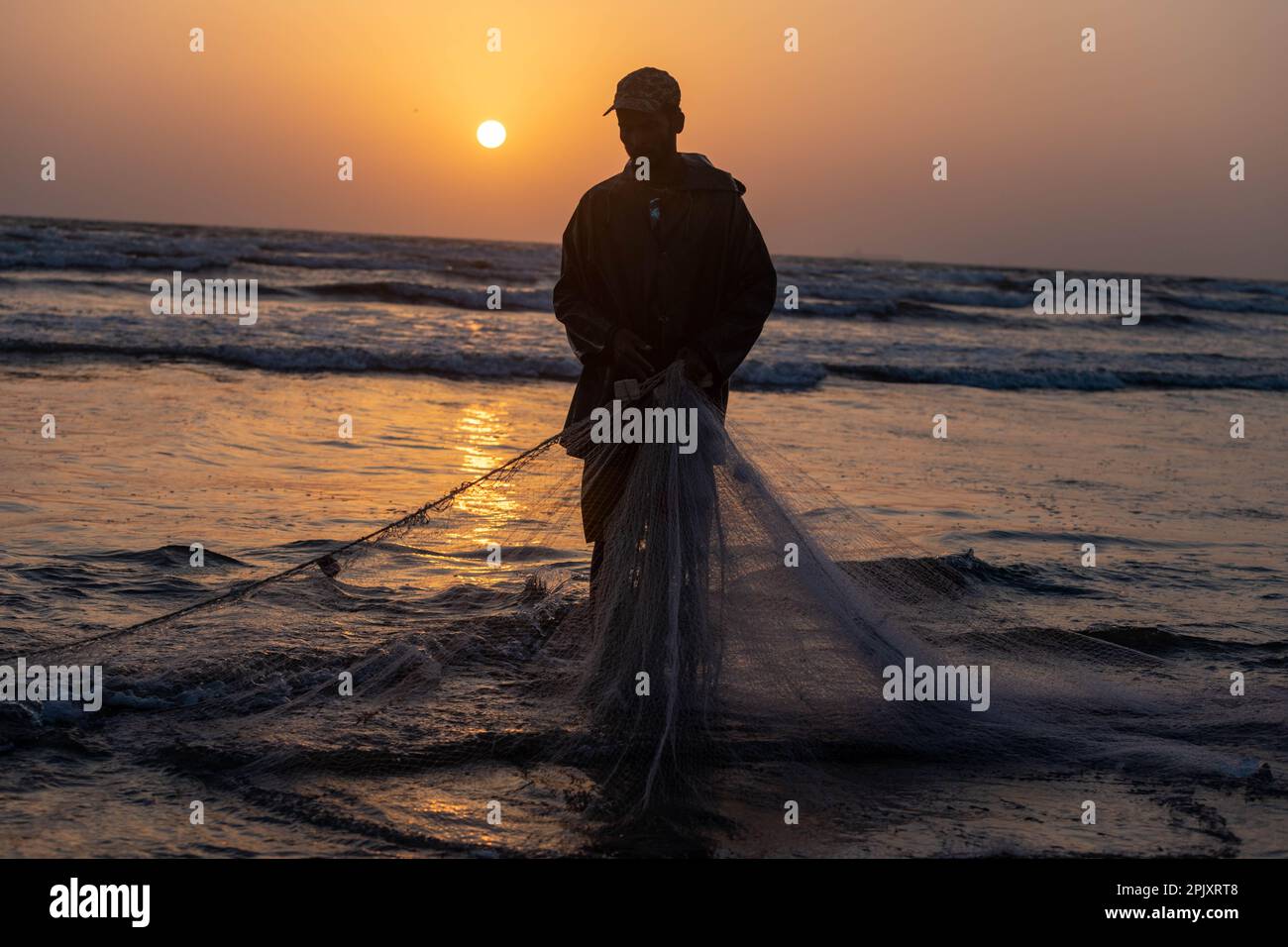 karachi pakistan 2021, a fisherman pulling fishing net to catch fish ...