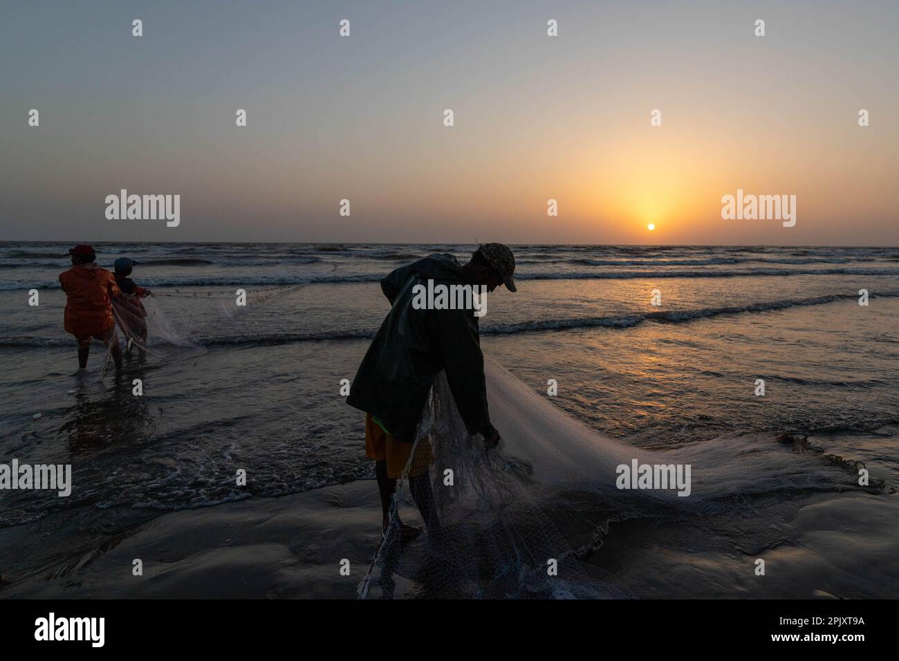 karachi pakistan 2021, a fisherman pulling fishing net to catch fish ...