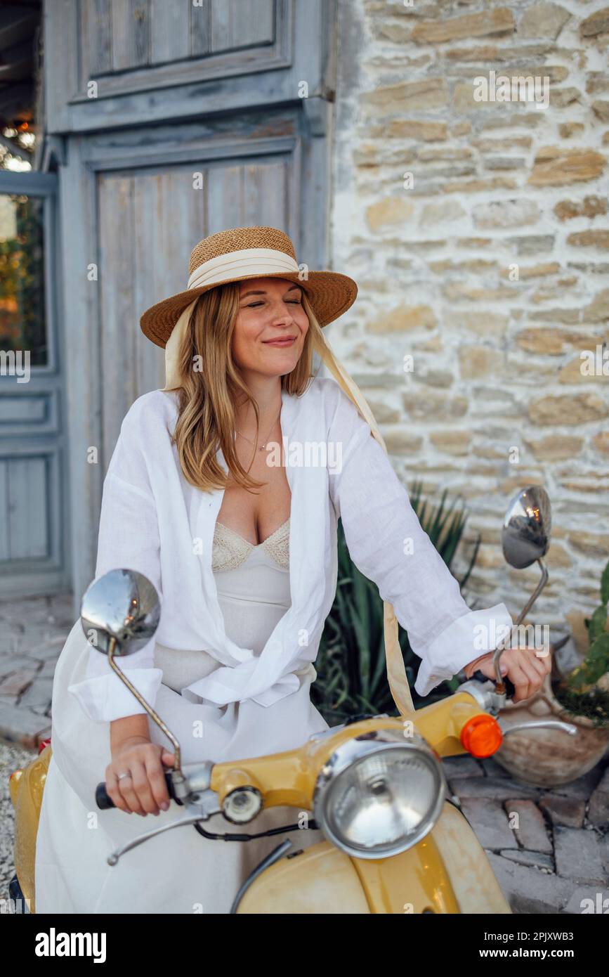 Beautiful female driver in white shirt and beige dress driving yellow ...