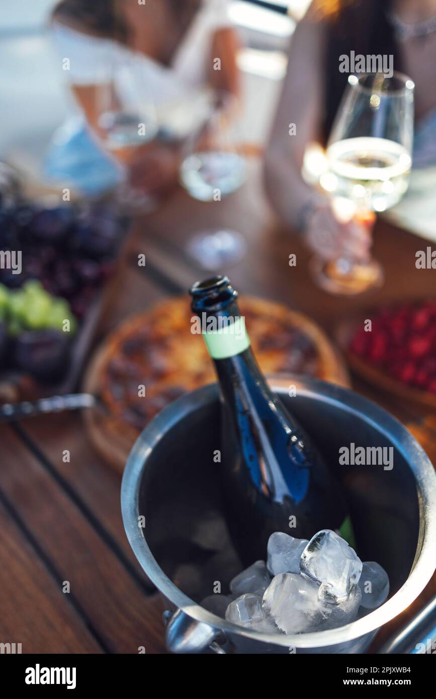 Close up of an open black bottle of champagne lying in ice cooler ...