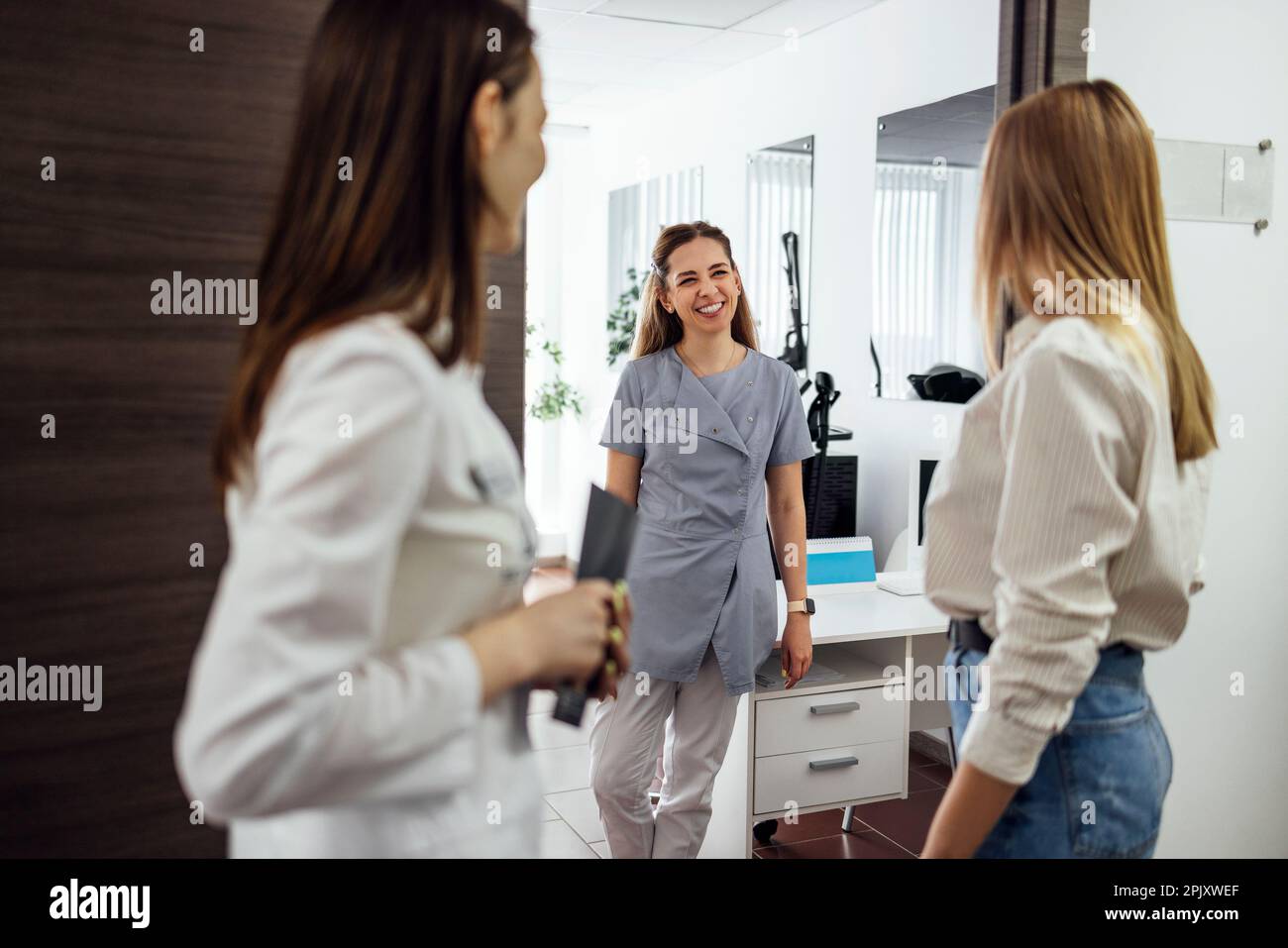 Joyful Female Beautician Meets Her New Client Three Women Communicate