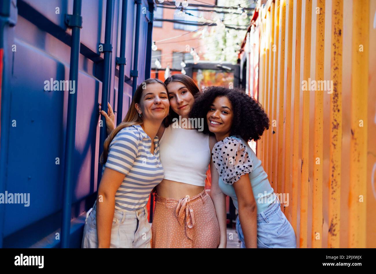 Three cute teenage girls in casual clothes on background of multi ...