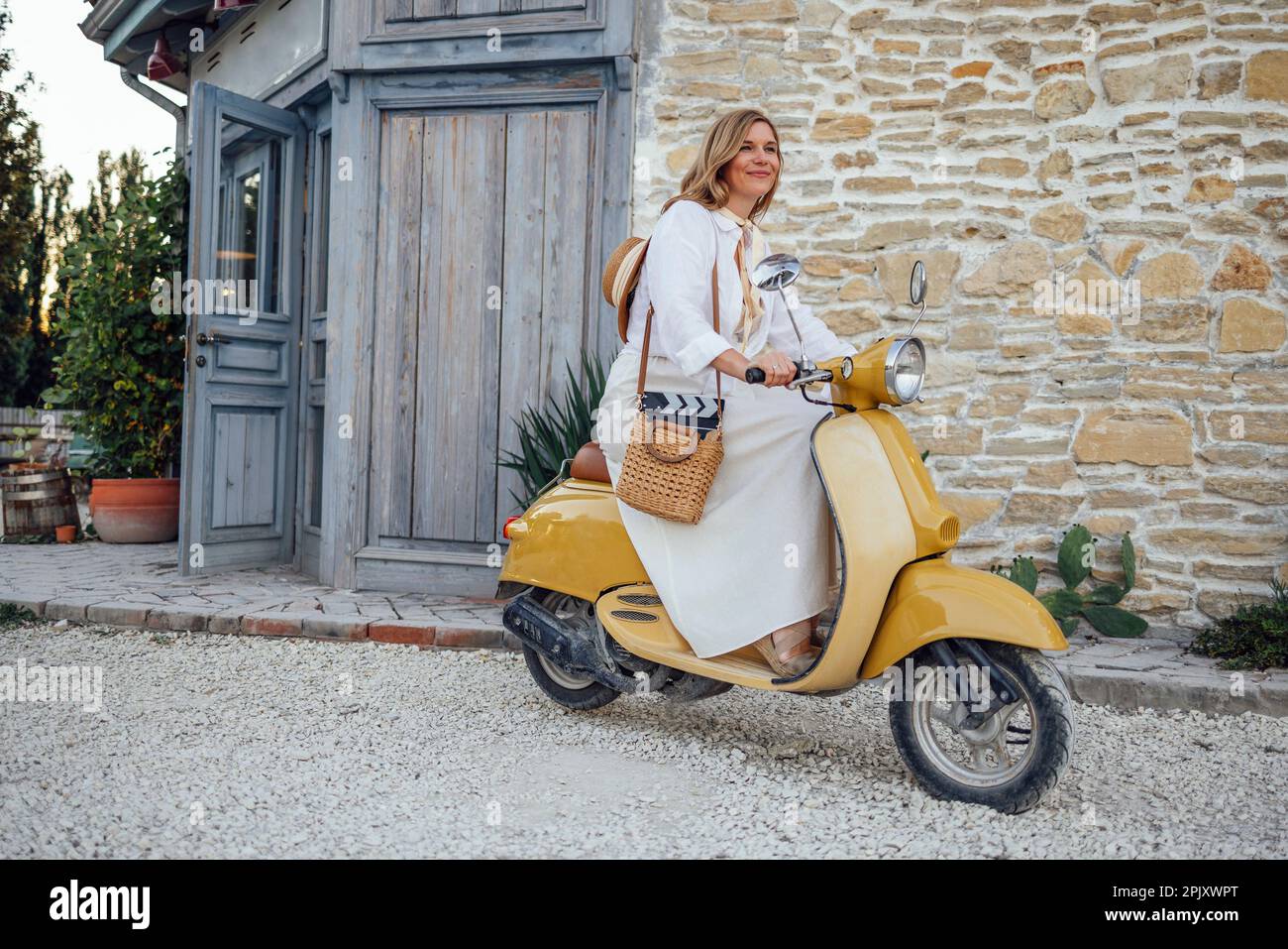Beautiful female driver in white shirt and beige dress driving yellow ...