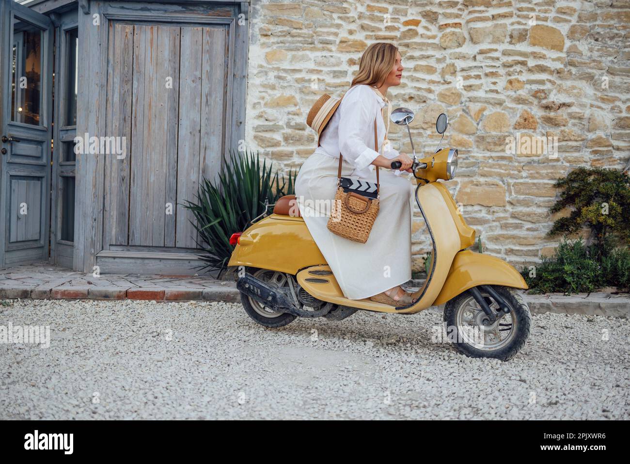 Beautiful female driver in white shirt and beige dress driving yellow ...
