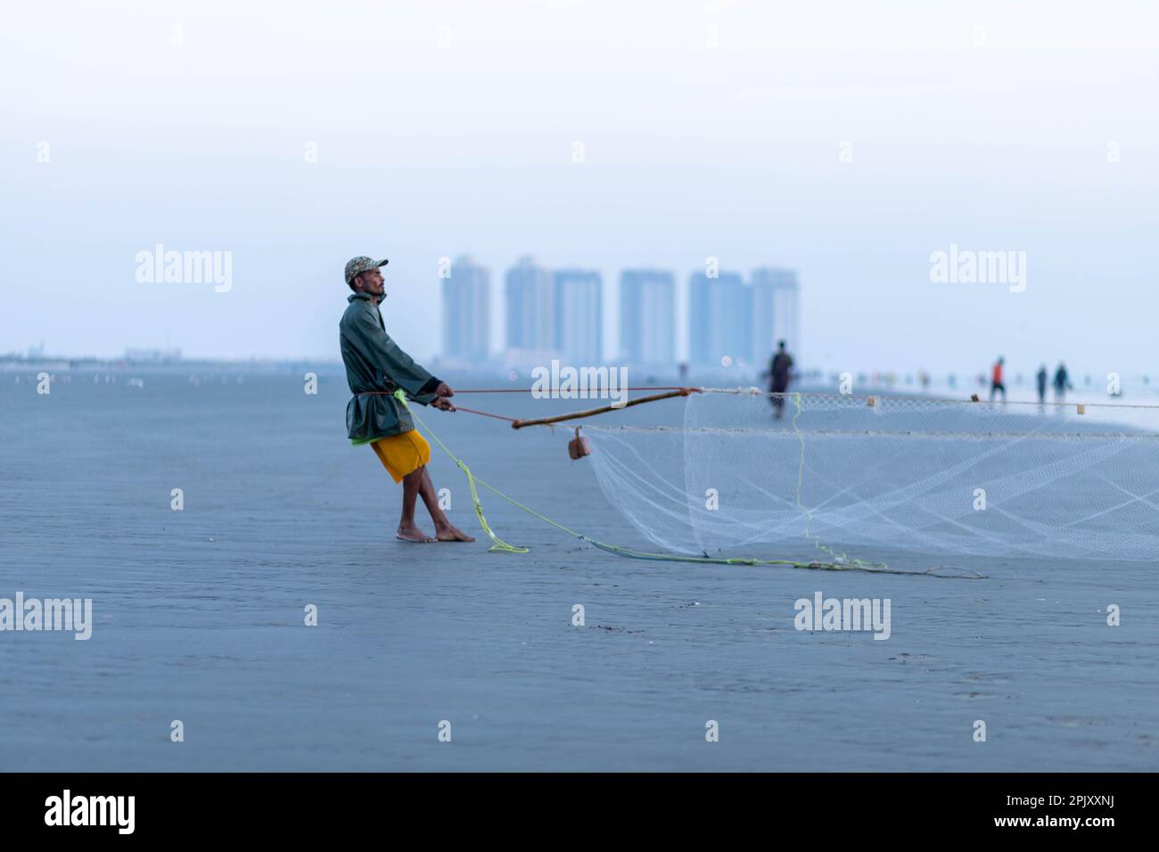 karachi pakistan 2021, a fisherman pulling fishing net to catch fish ...