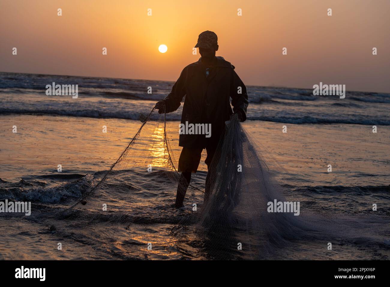 karachi pakistan 2021, a fisherman pulling fishing net to catch fish ...