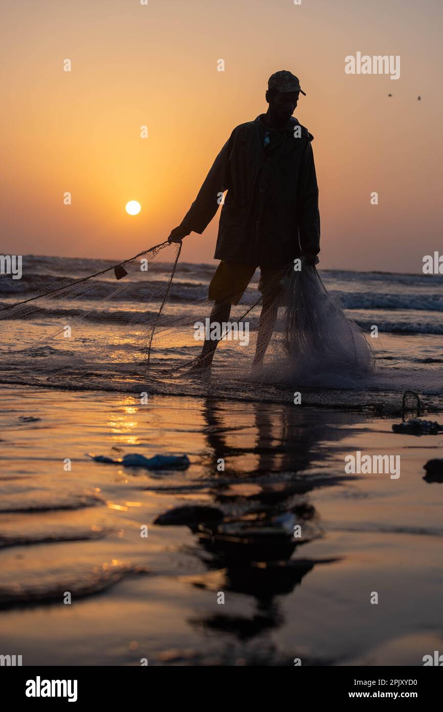karachi pakistan 2021, a fisherman pulling fishing net to catch fish ...