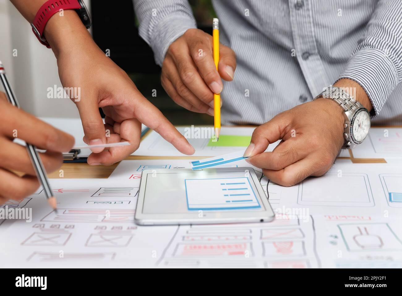 UX or UI designers designing on their smartphone application layout ...