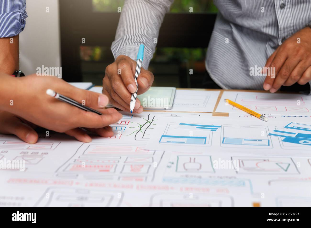 UX or UI designers designing on their smartphone application layout ...