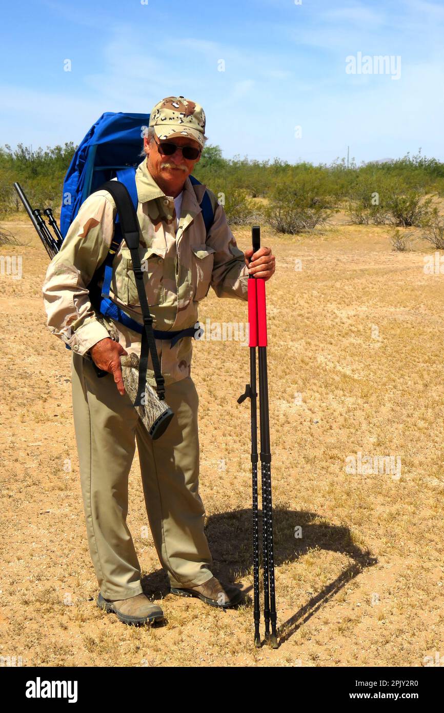 Senior hunter in sonora desert carrying rifle and pack Stock Photo - Alamy
