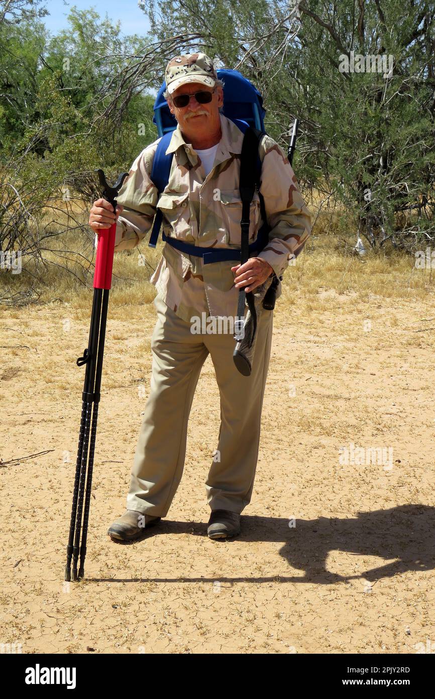 Senior hunter in sonora desert carrying rifle and pack Stock Photo - Alamy