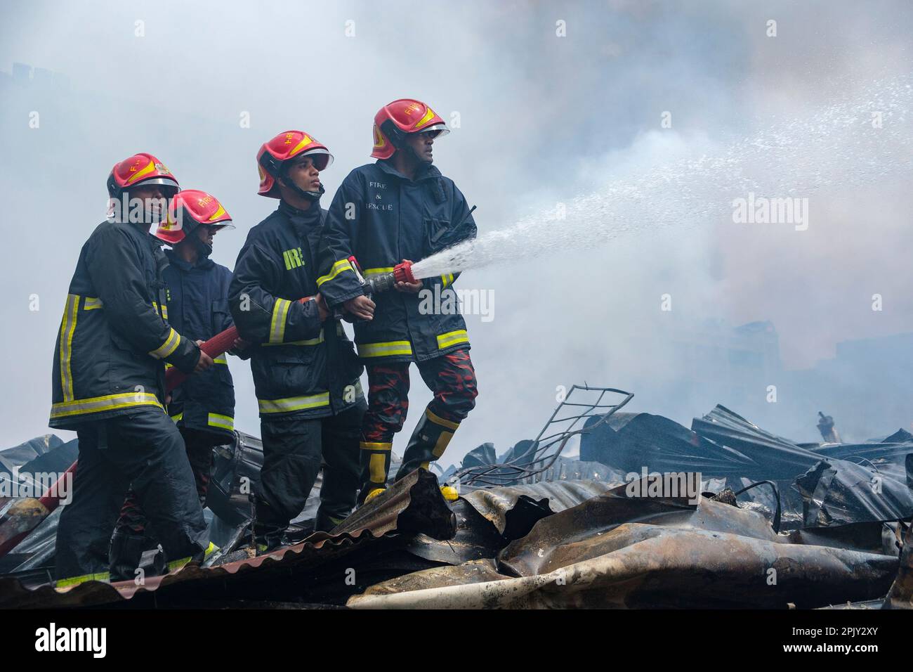 Fire-fighters spray water in their attempt to tame the fire.On the dawn ...