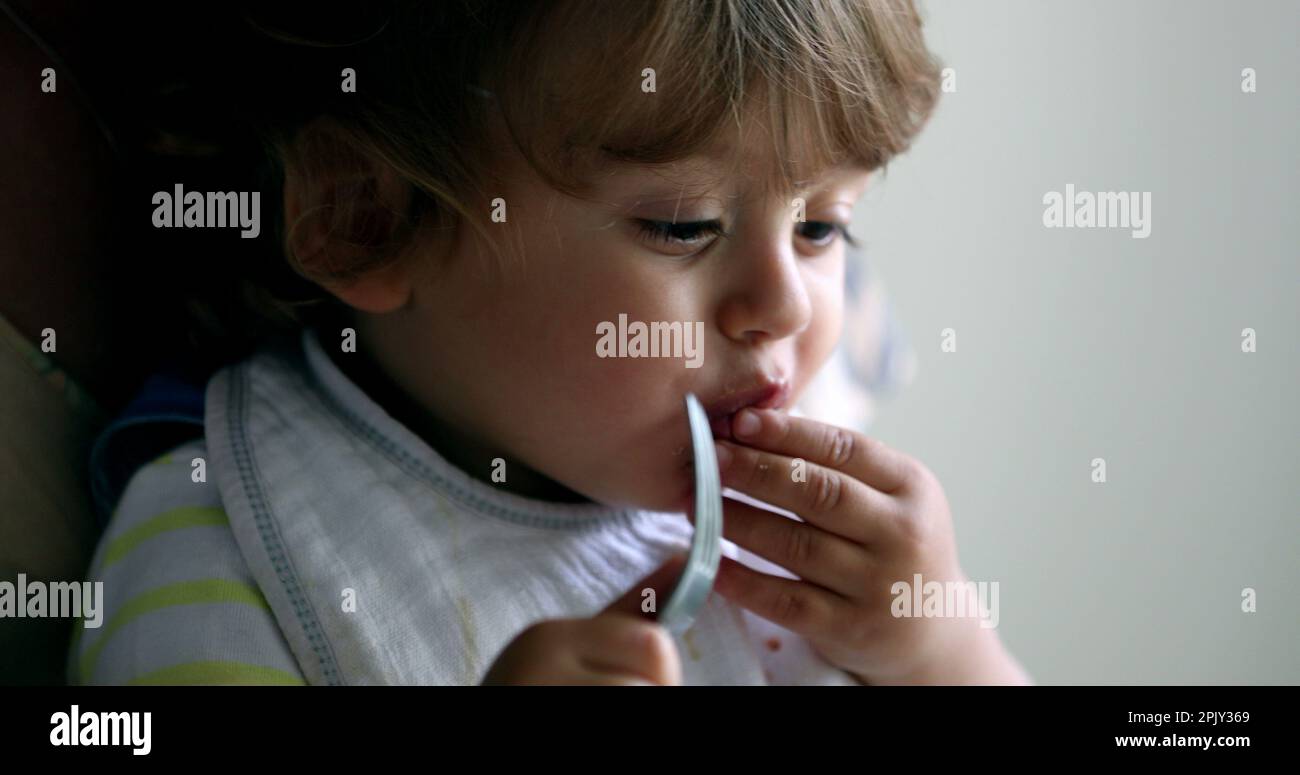 Baby child eating with mother. Candid mom and infant boy eating meal ...