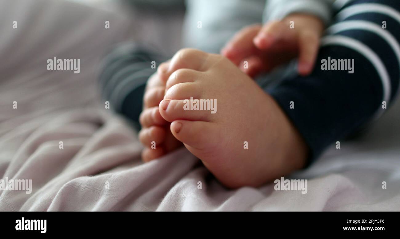 Toddler boy touchign toes. one year old Infant child baby feet Stock ...