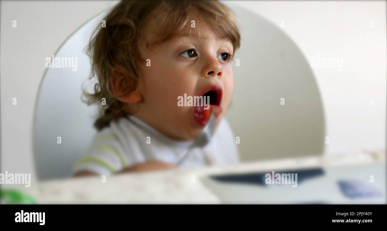 Infant boy eating with fork. Child baby eats fruit Stock Photo - Alamy
