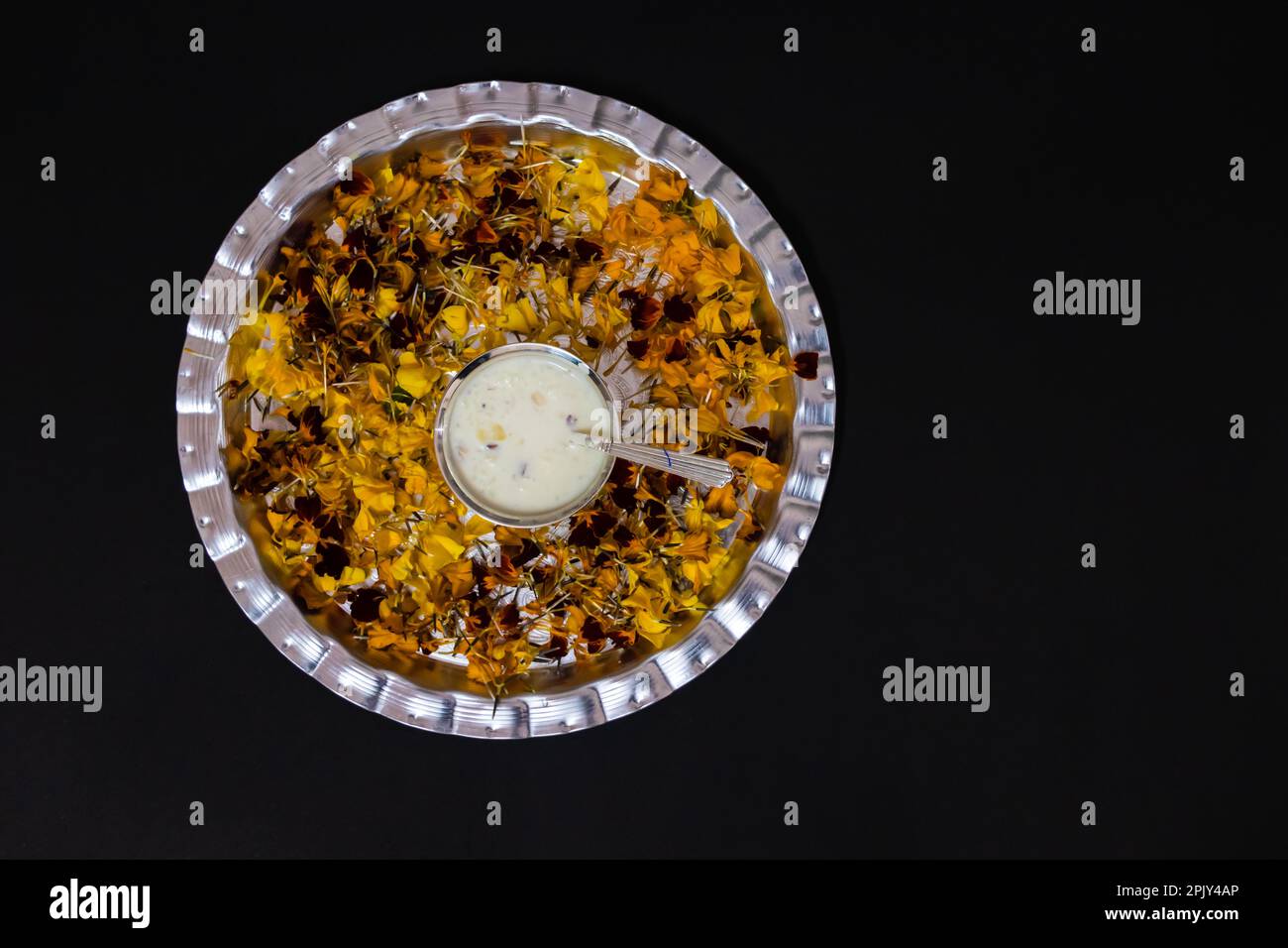 sweet rice pudding in silver bowel decorated with flowers petals and ...