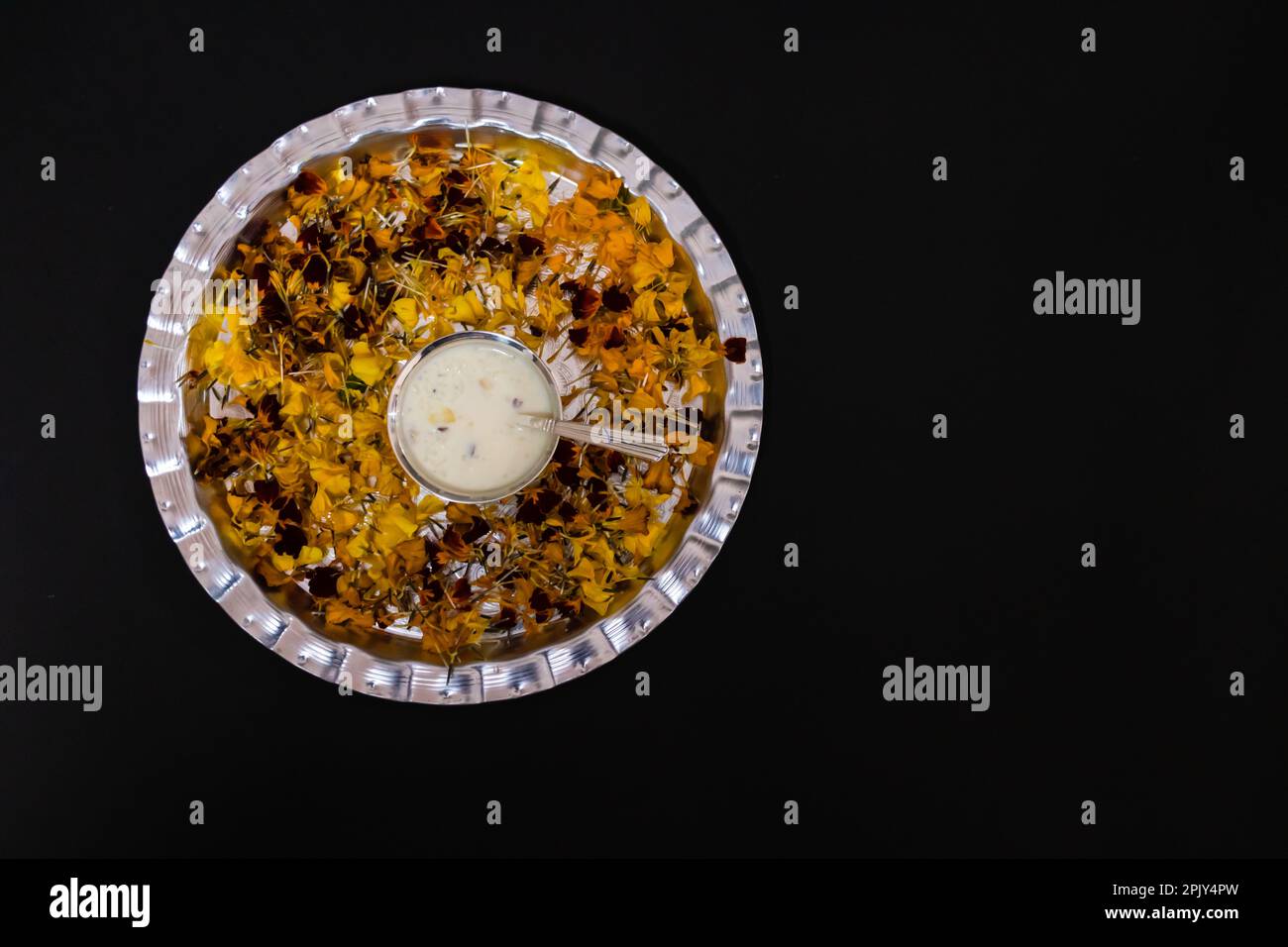 sweet rice pudding in silver bowel decorated with flowers petals and ...